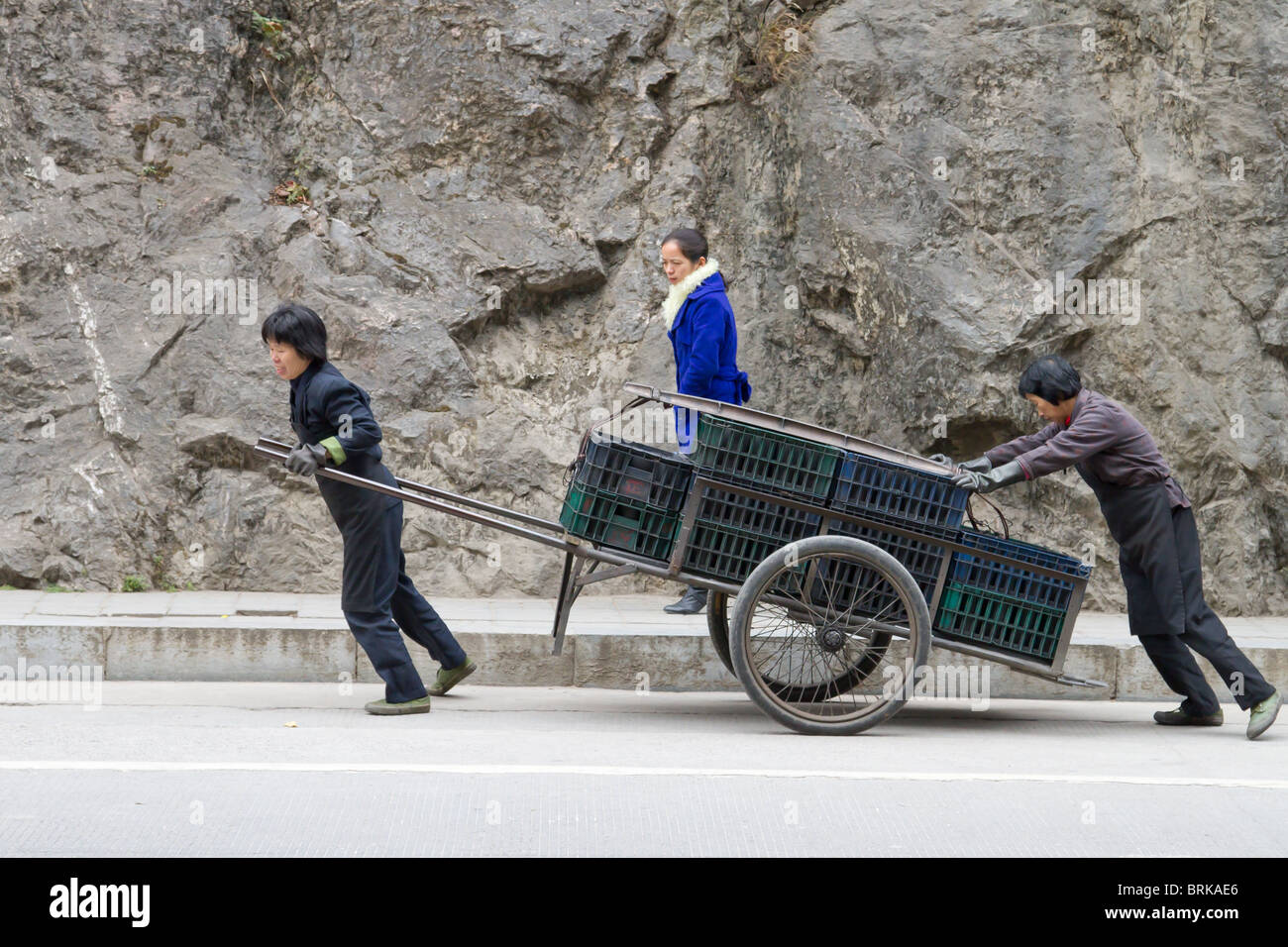 Two Chinese women push a cart loaded with coal Stock Photo - Alamy