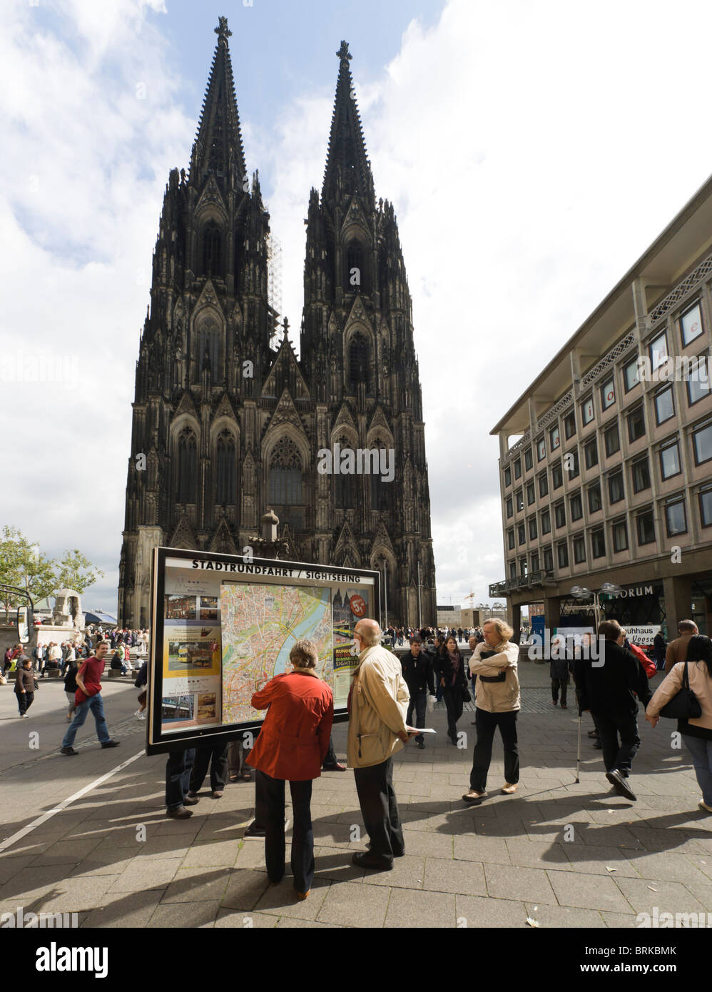 Cologne - tourists studying the city map with the cathedral in ...