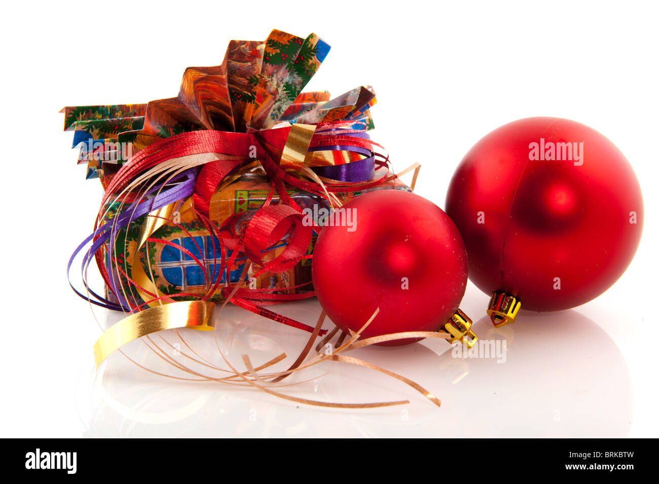 Luxury wrapped Christmas gift with red balls isolated over white ...