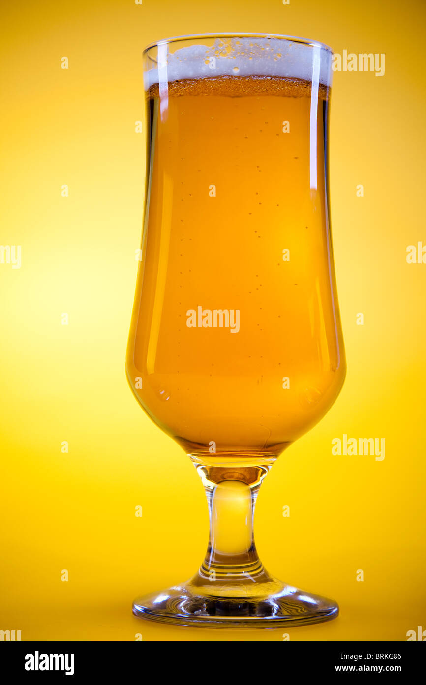 Beer glass with yellow background Stock Photo - Alamy