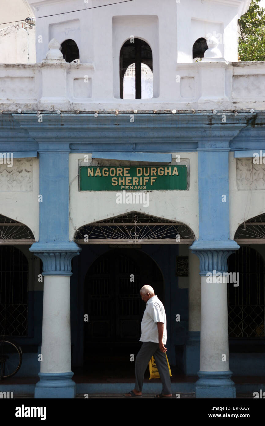 A man carrying a shopping bag walks past the Nagore Durgha Sheriff ...