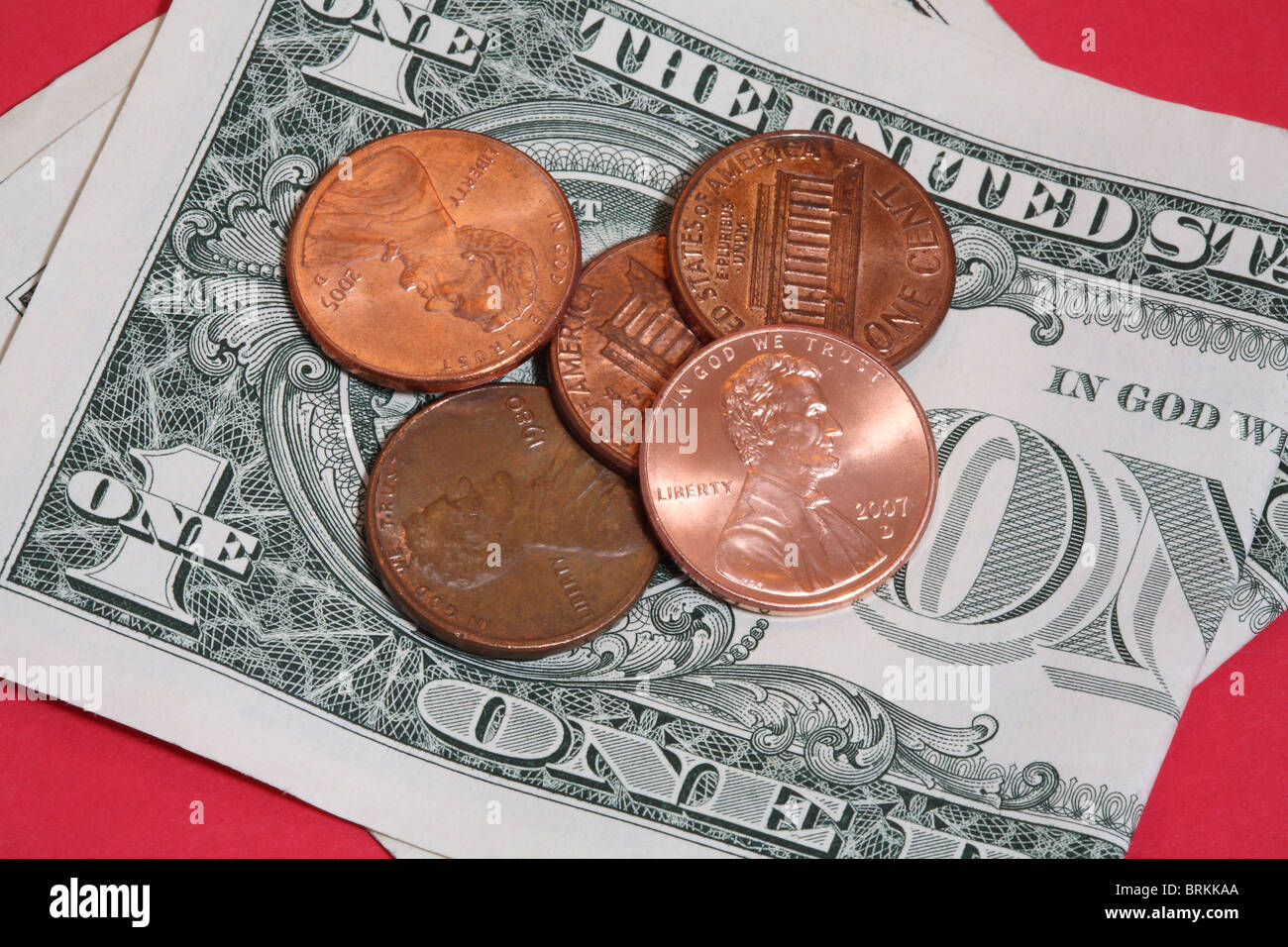 Dollar bills on a red paper background with cent coins Stock Photo - Alamy