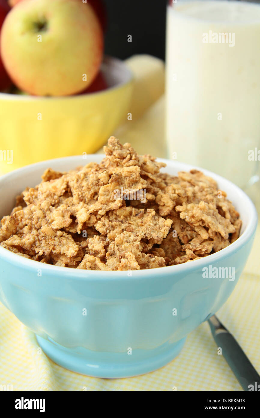 muesli breakfast in the blue cup and an apple with milk in the ...