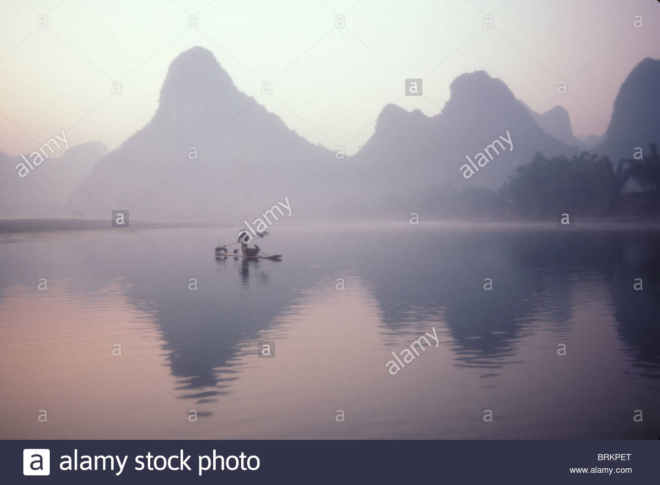 A cormorant Fisher, works the Li River at dawn Stock Photo - Alamy