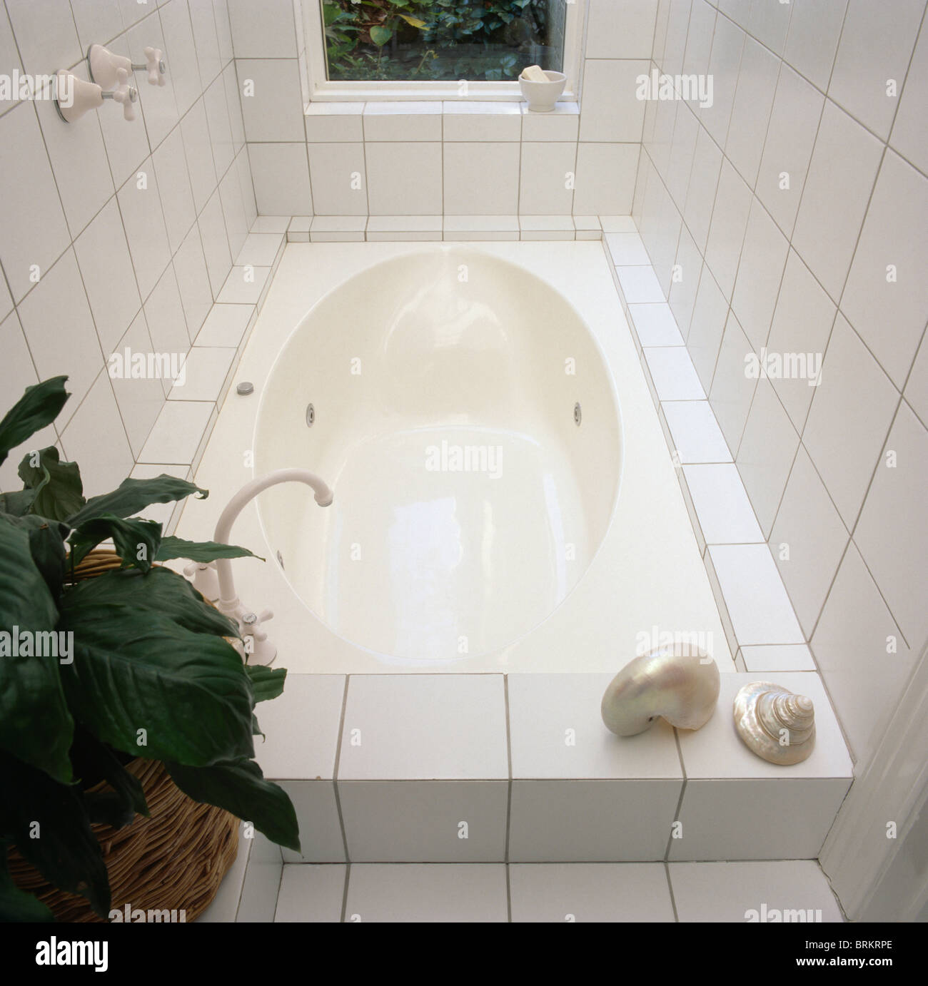 Close-up of fitted bath in small modern white tiled bathroom Stock ...