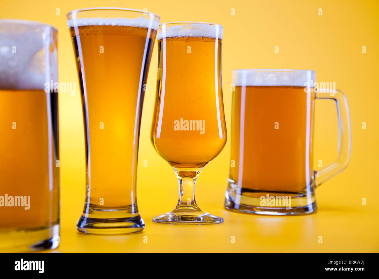 Beer glass with yellow background Stock Photo - Alamy