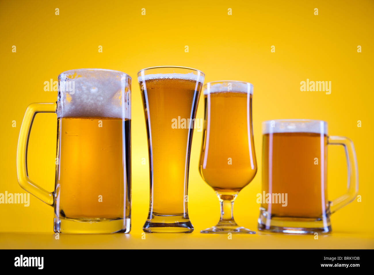 Beer glass with yellow background Stock Photo - Alamy