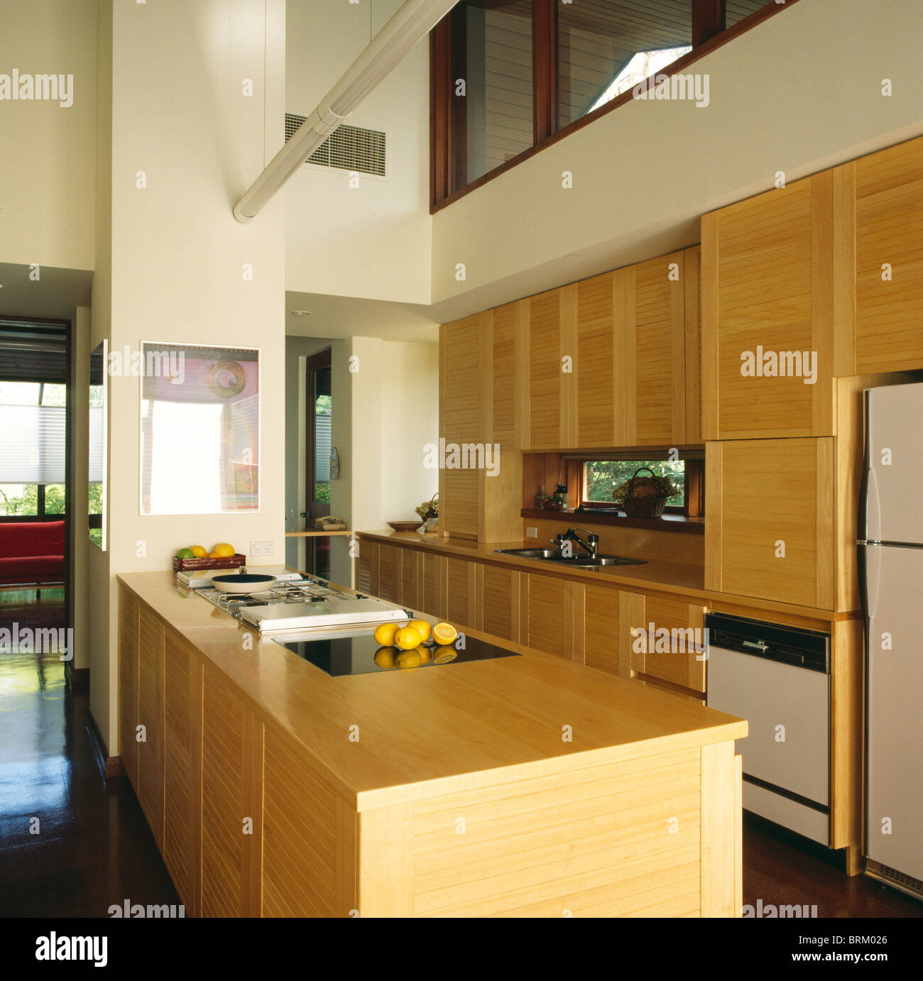 Peninsular unit with fitted hob in modern double-height kitchen with ...