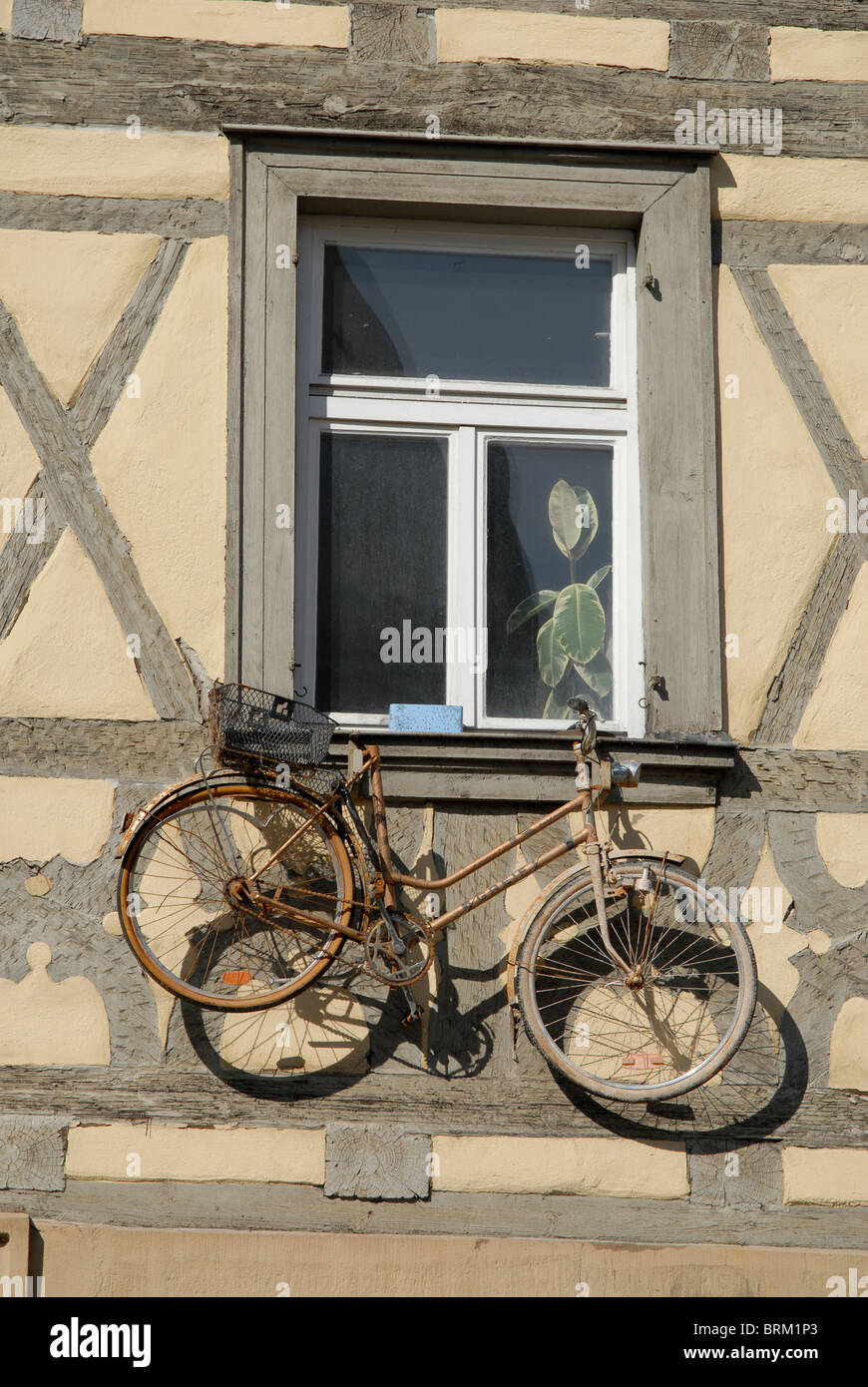 Old bicycle hanging below a window, Bamberg, Germany Stock Photo - Alamy