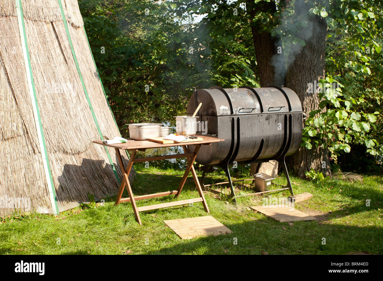 Traditional outdoor barbecue smoker in a lush green backyard Stock ...