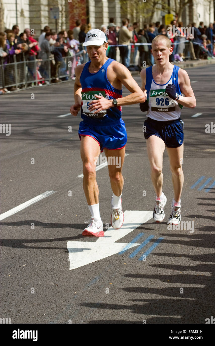 two male competitive runners taking part in the London Marathon running ...