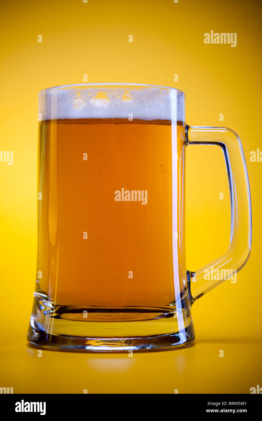 Beer glass with yellow background Stock Photo - Alamy