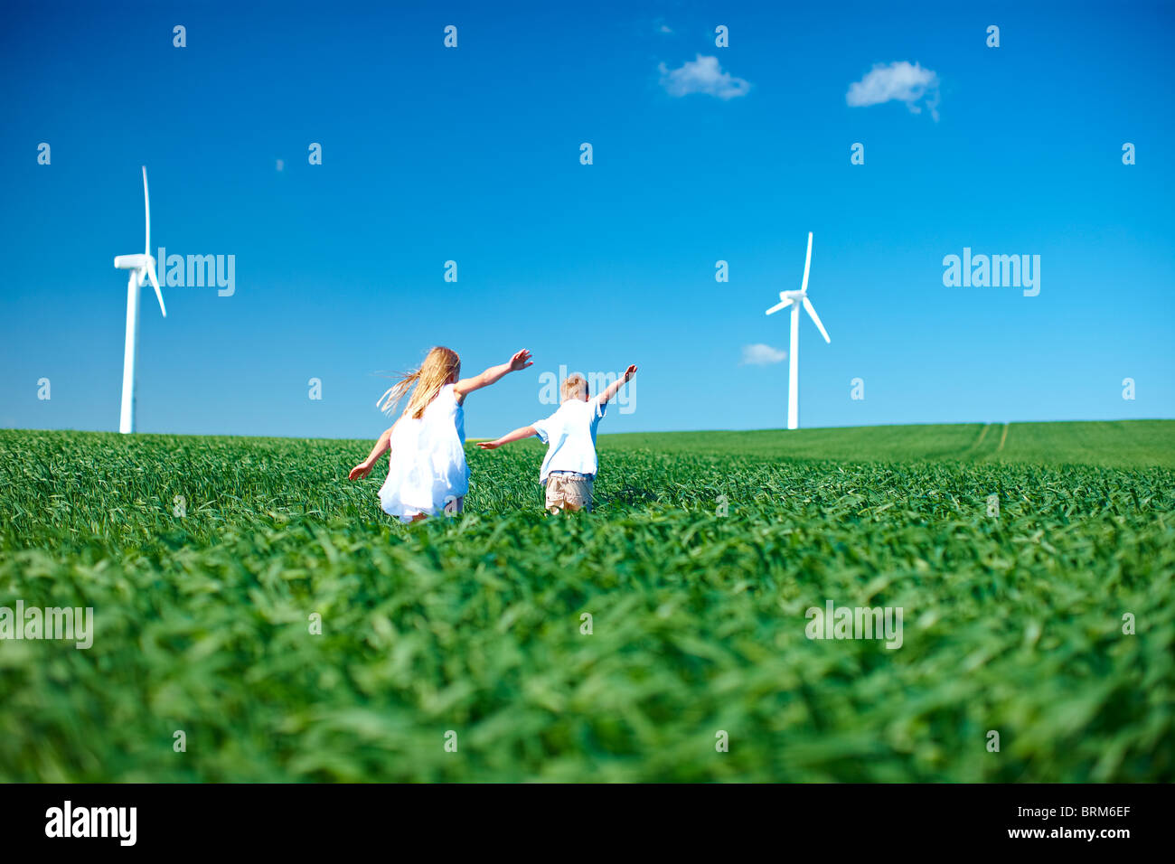 Childrens play in field & wind turbines Stock Photo - Alamy