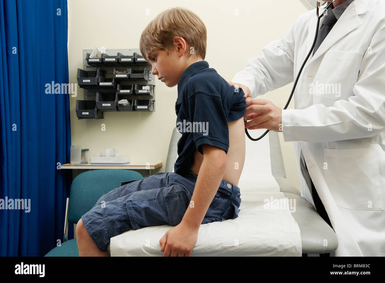 Doctor examining young boy Stock Photo - Alamy