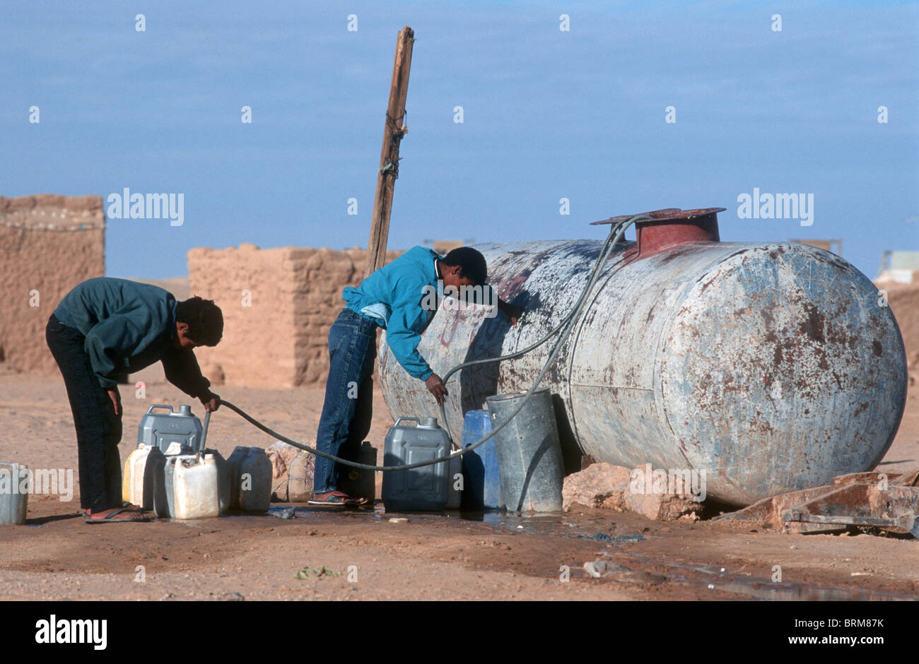 WESTERN SAHARA REFUGEE CHILDREN FETCHING WATER FROM TANK IN DESERT CAMP ...