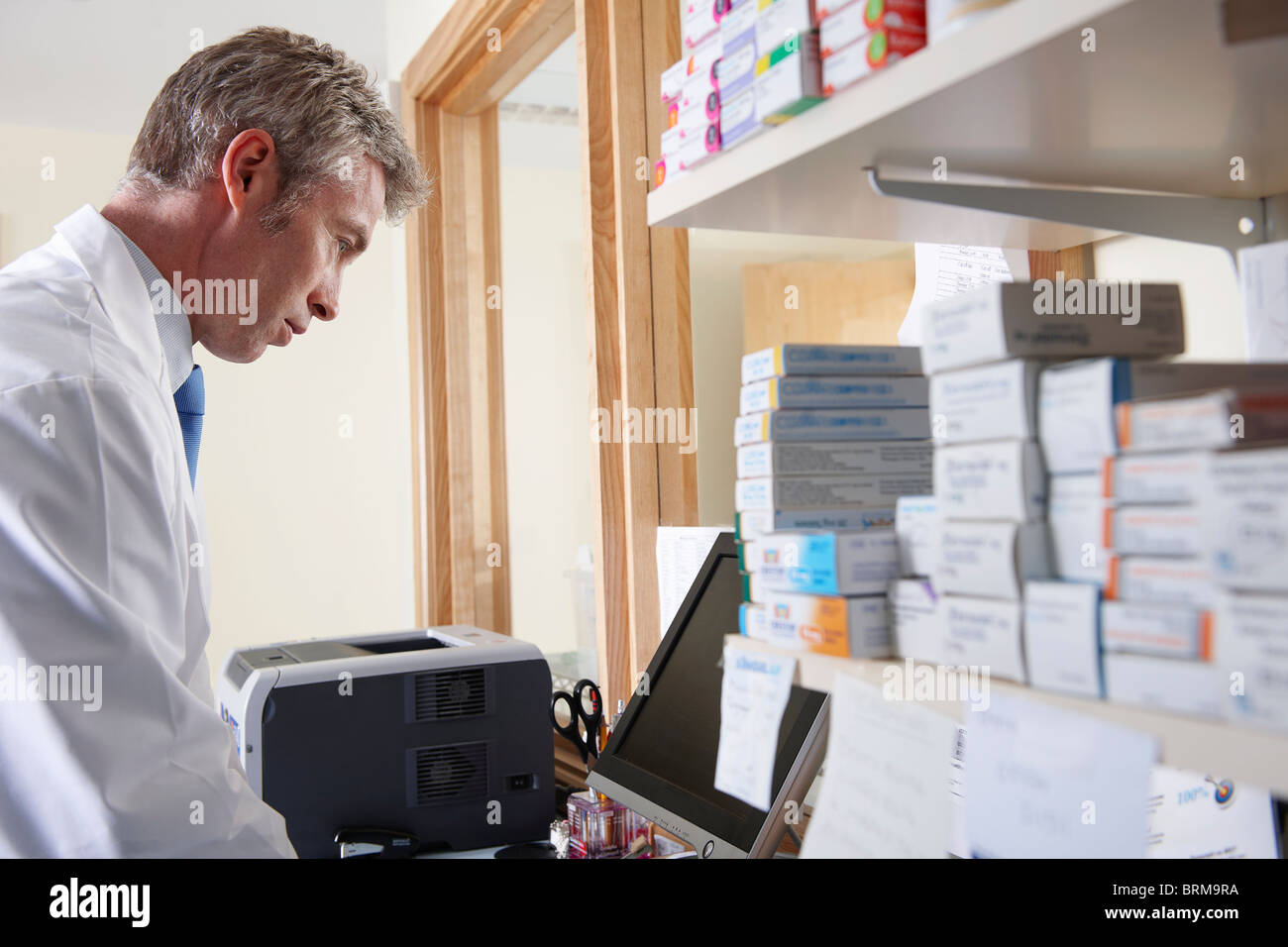 Pharmacist looking at computer Stock Photo - Alamy