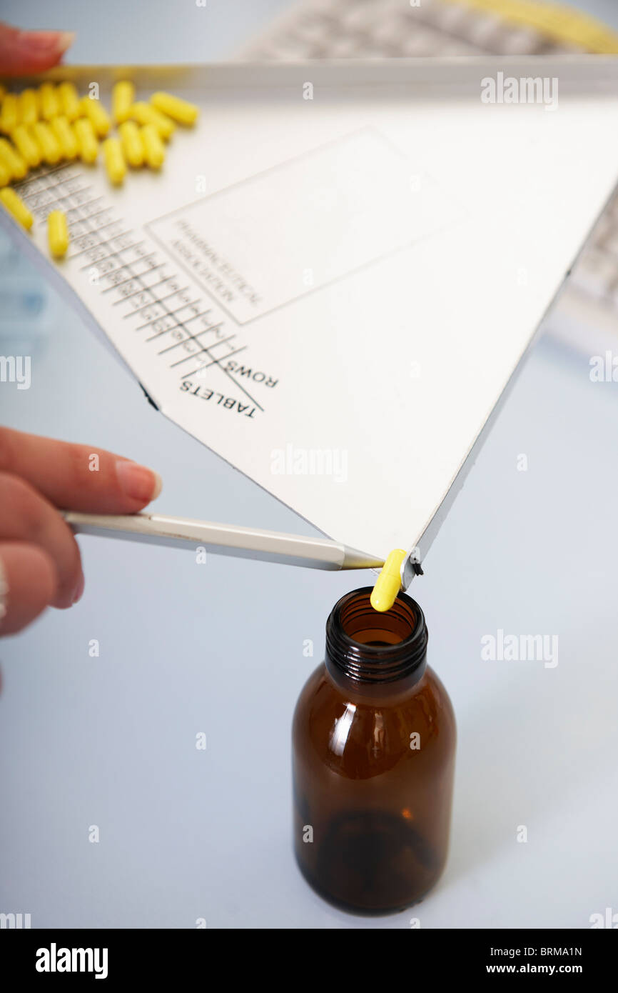 Pharmacist counting pills Stock Photo - Alamy