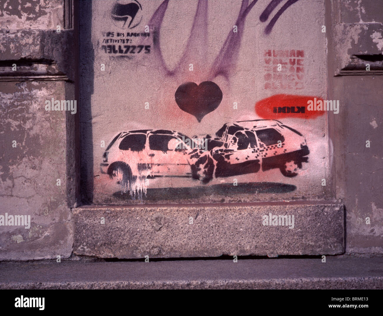 Graffito showing frontal car crash and a black heart on a wall in ...
