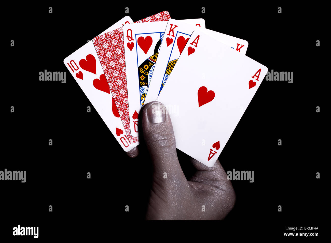 Playing cards in the silver male hand isolated on black background ...