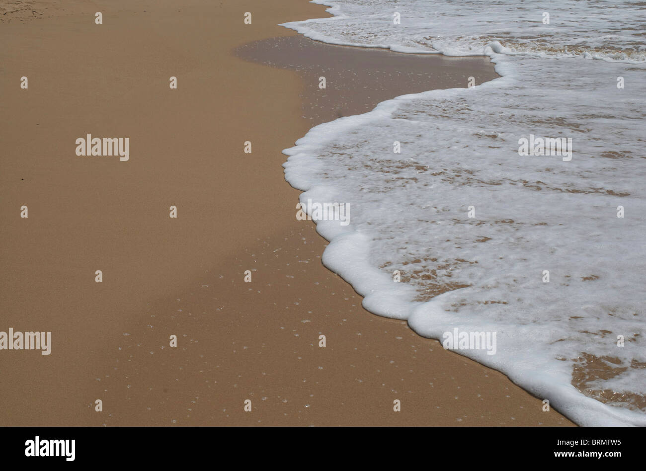 Sand and wave Stock Photo - Alamy