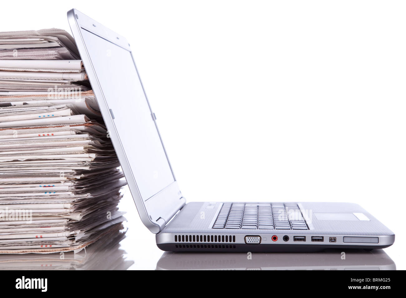 stack of newspaper next to a laptop (isolated on white Stock Photo - Alamy