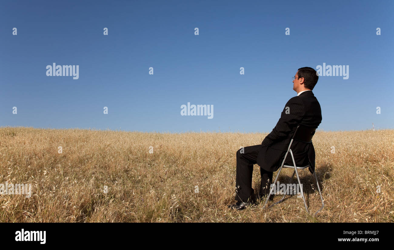 businessman sited in a chair looking to the landscape Stock Photo - Alamy