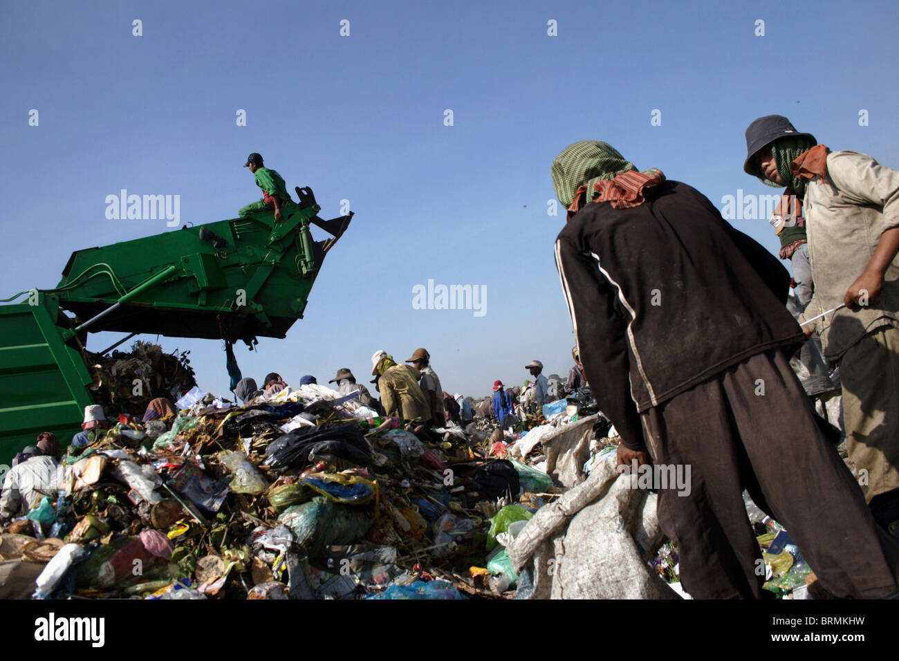 A worker is sitting on top of a garbage truck at the Stung Meanchey ...