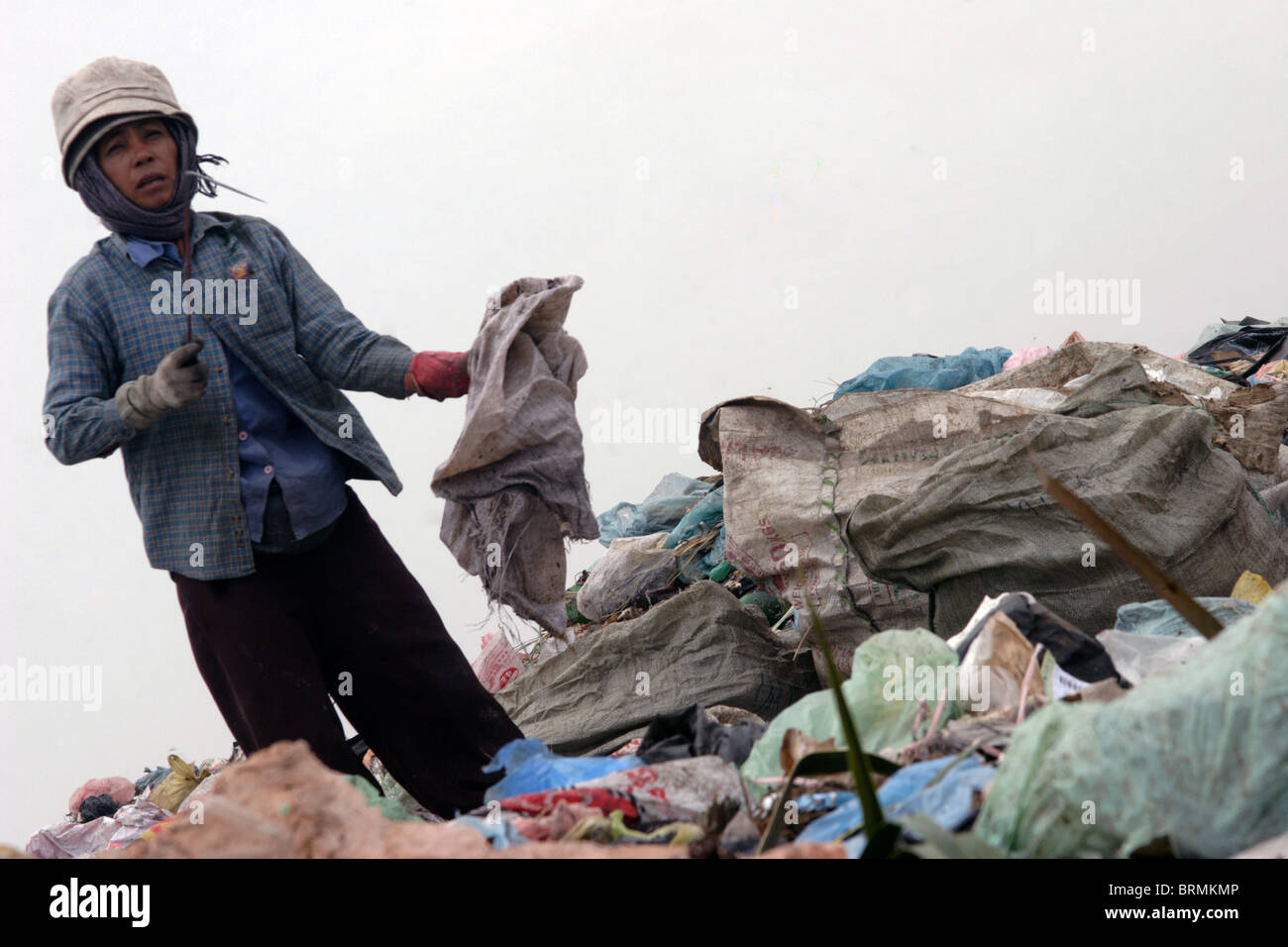 A worker holds a gaff while looking through garbage for clear plastic ...