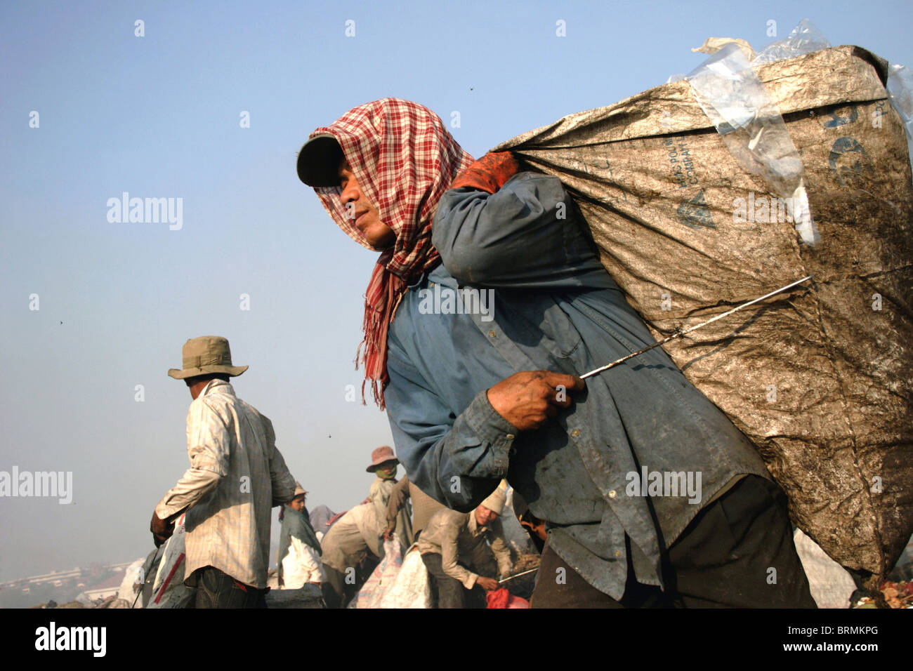 A worker uses a gaff to steady a sack filled with garbage at The Stung ...