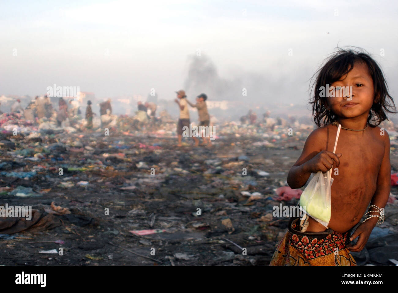 A young child laborer girl has a refreshment to quench her thirst at ...