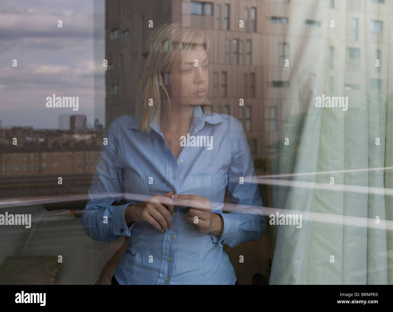 Woman looking out of window Stock Photo - Alamy
