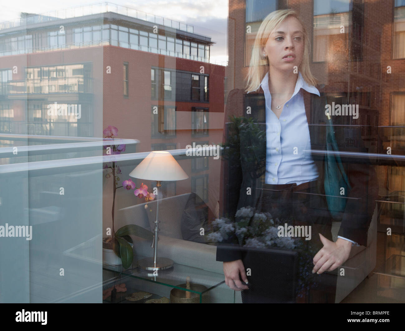 Woman looking out of window Stock Photo - Alamy