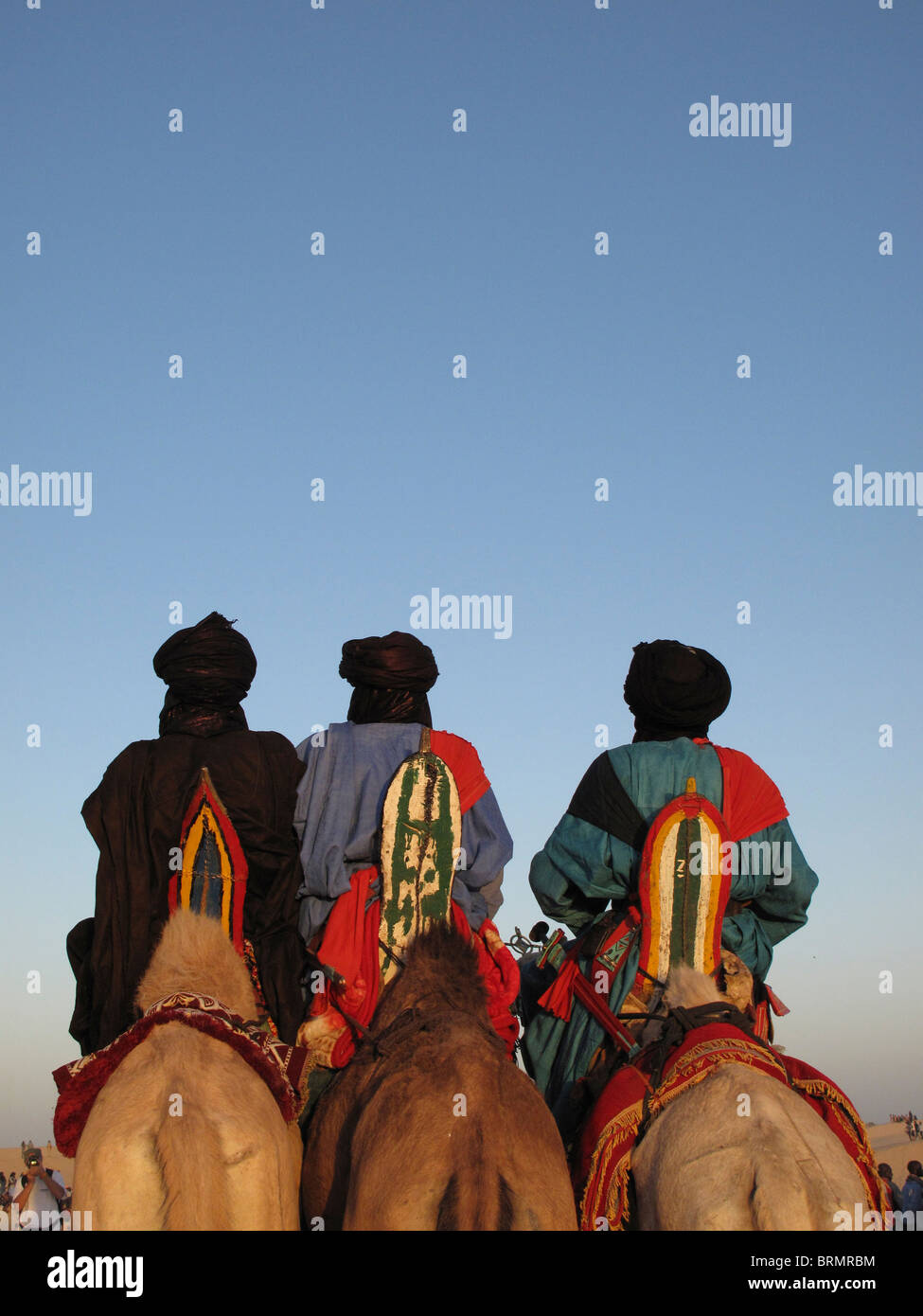 Tuareg man on a camel dressed in traditional robes watching a ...