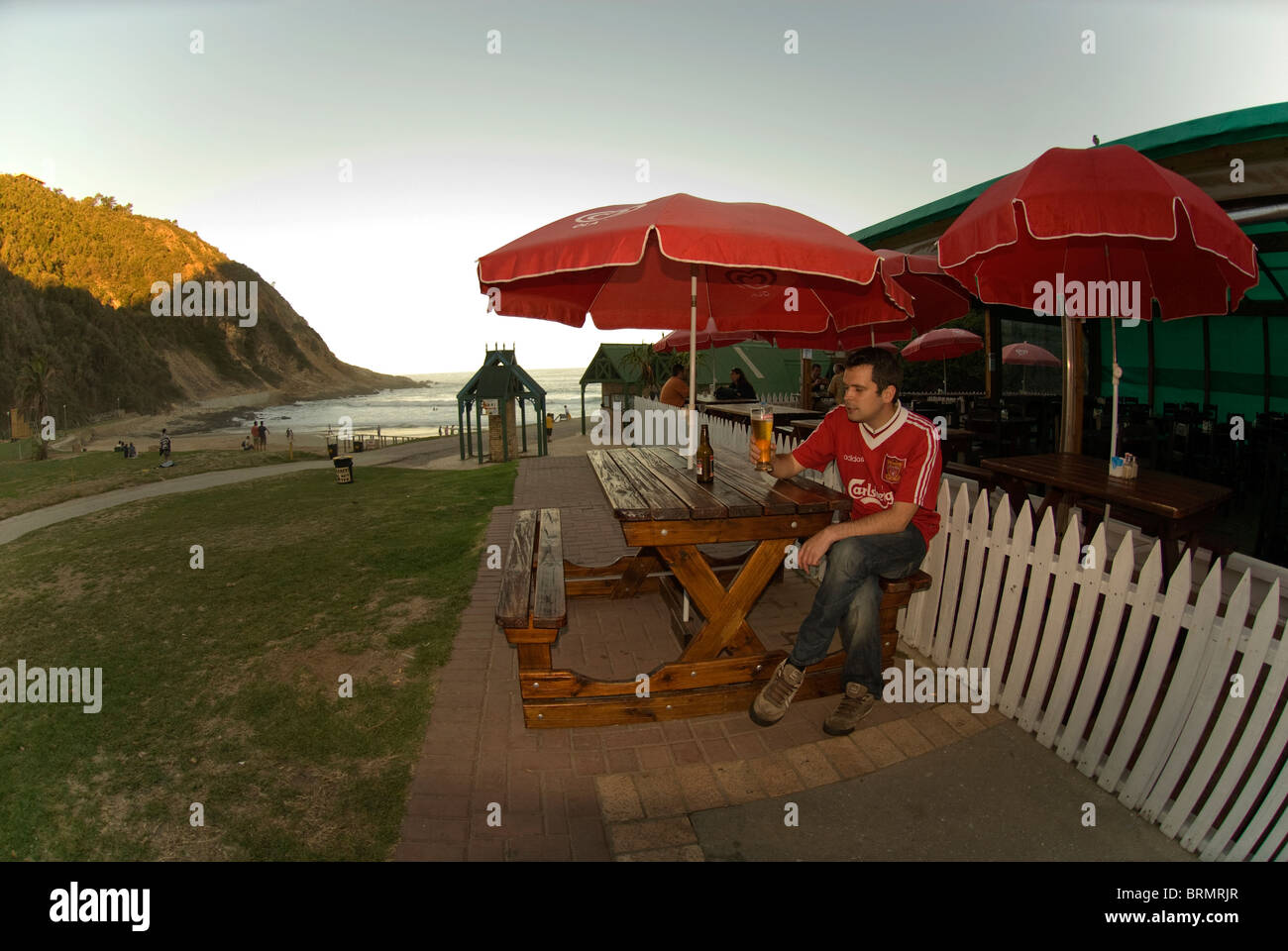 Patron enjoying a beer at a waterfront pub in Victoria Bay (model ...