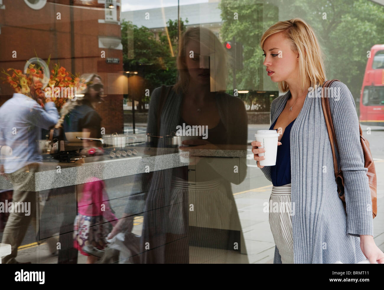 Woman looking in shop window Stock Photo - Alamy