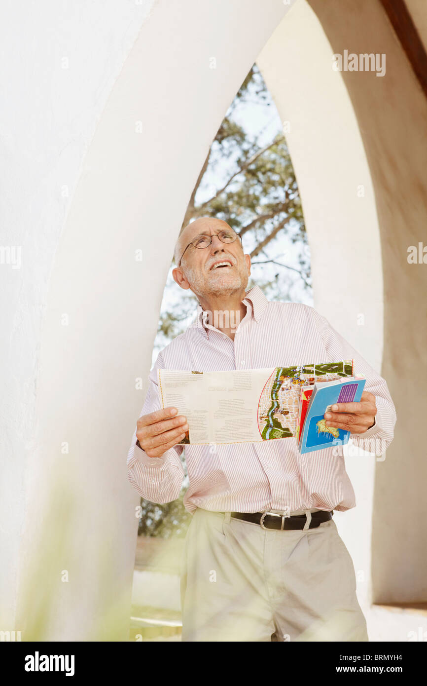 Older man with guidebooks Stock Photo - Alamy