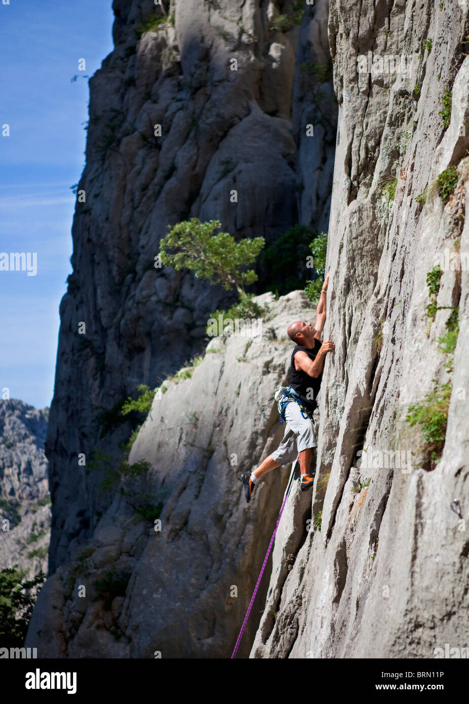 Rock climber climbing rock face Stock Photo - Alamy