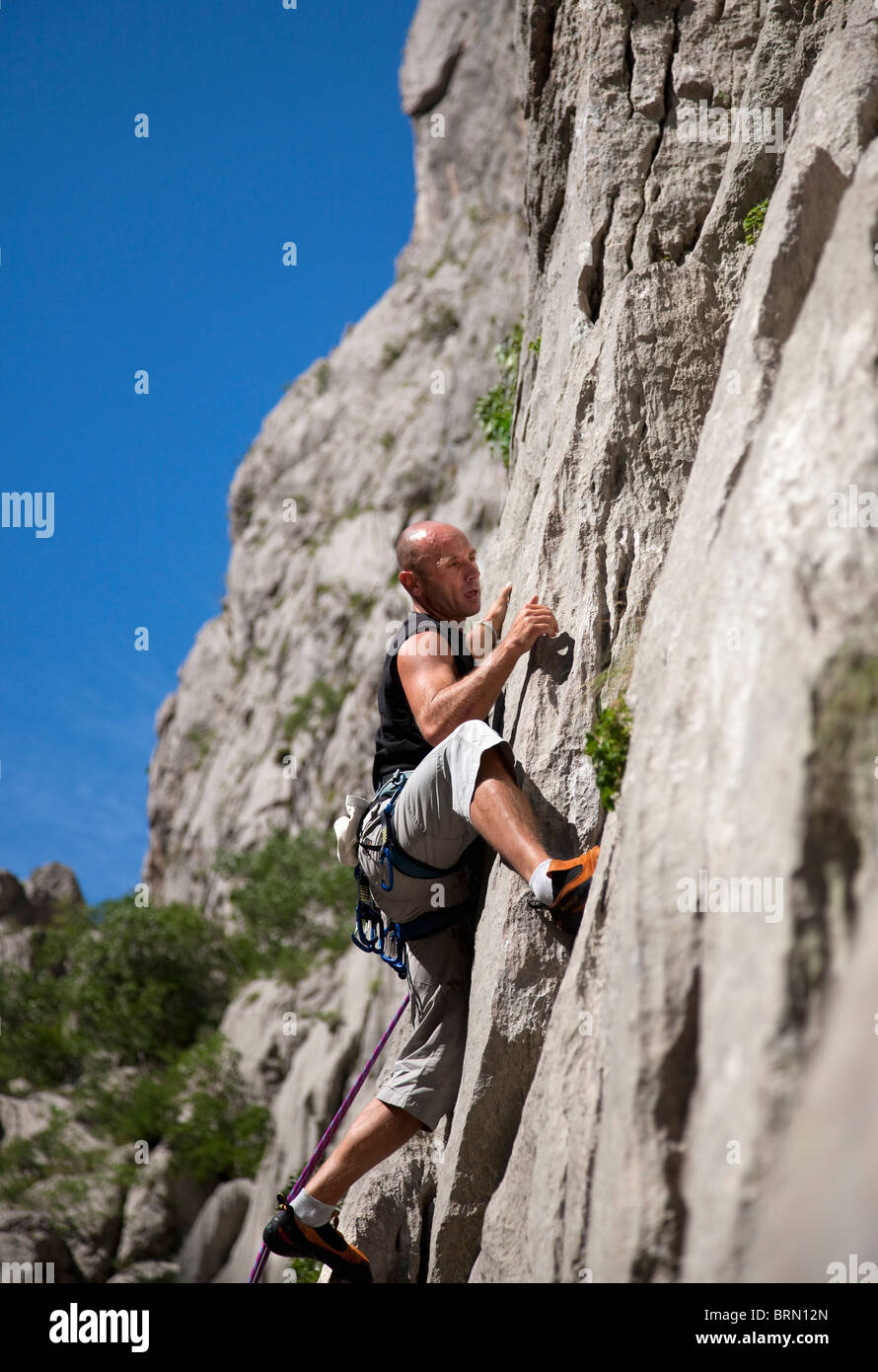 Rock climber climbing rock face Stock Photo - Alamy