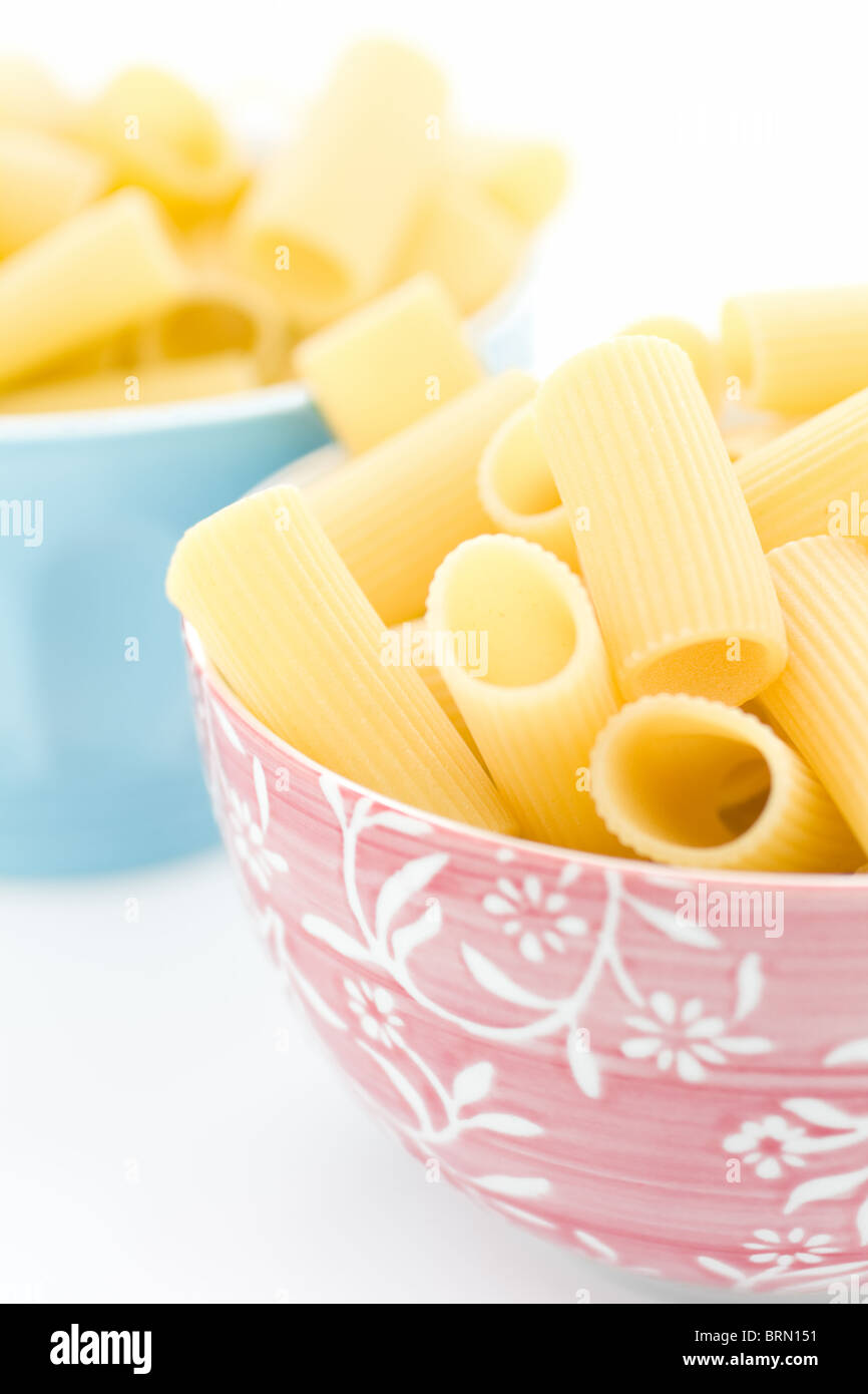 Raw italian pasta in pink and blue bowls Stock Photo - Alamy