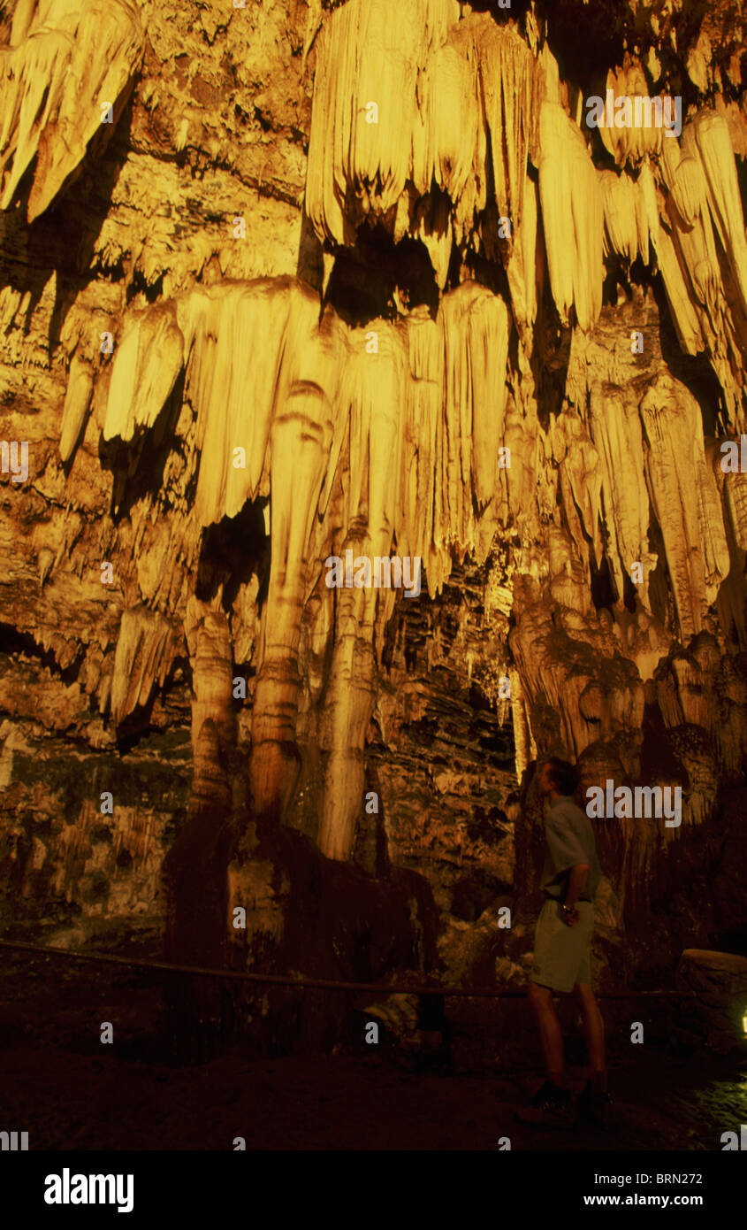 A tourist gazes up at stalactites and stalagmites in the Wonder cave ...