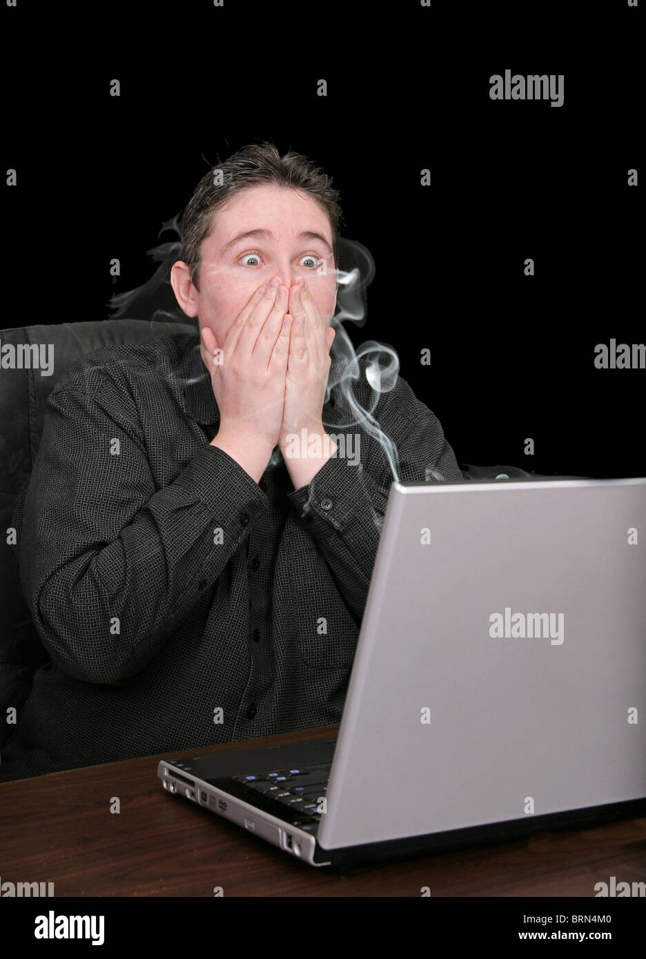 man surprised at smoking, damaged computer Stock Photo - Alamy