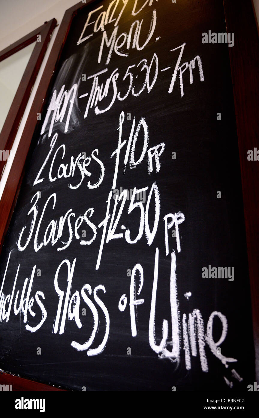 A chalkboard menu and printed menu in a restaurant Stock Photo - Alamy