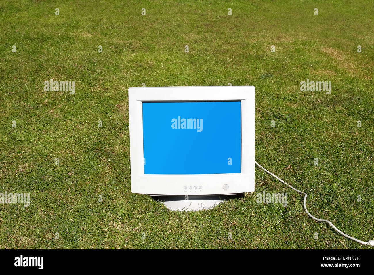 computer monitor on the grass depicting outsourcing Stock Photo - Alamy