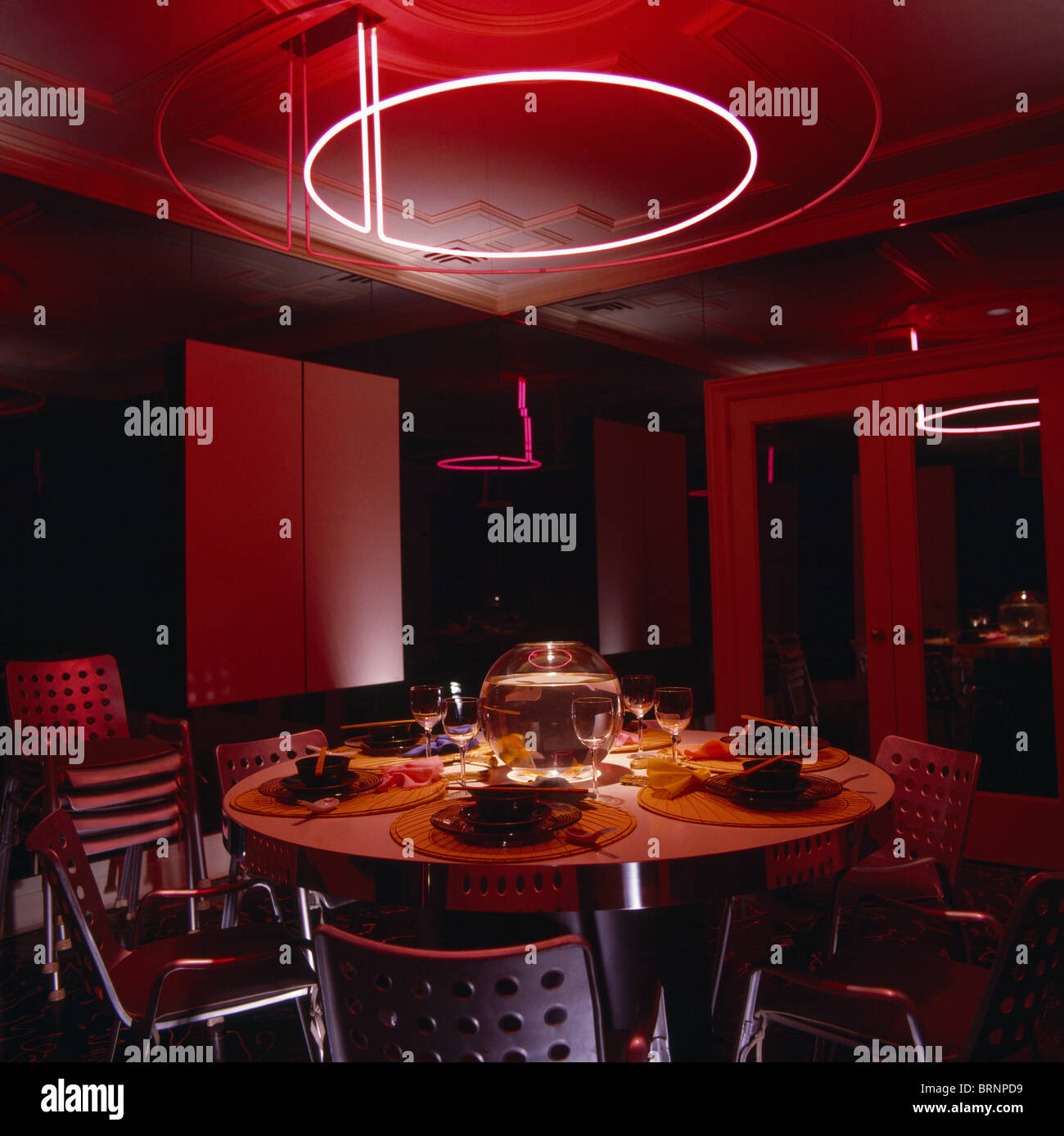 Circular table set for dinner below circular flurorescent light fitting ...