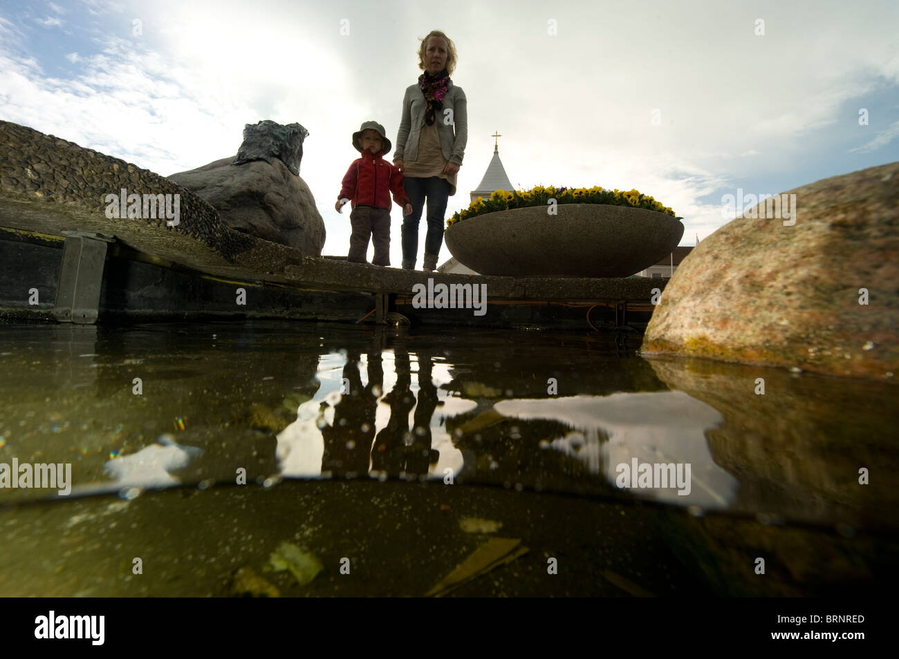 Mother and child throwing money in fountain Stock Photo - Alamy