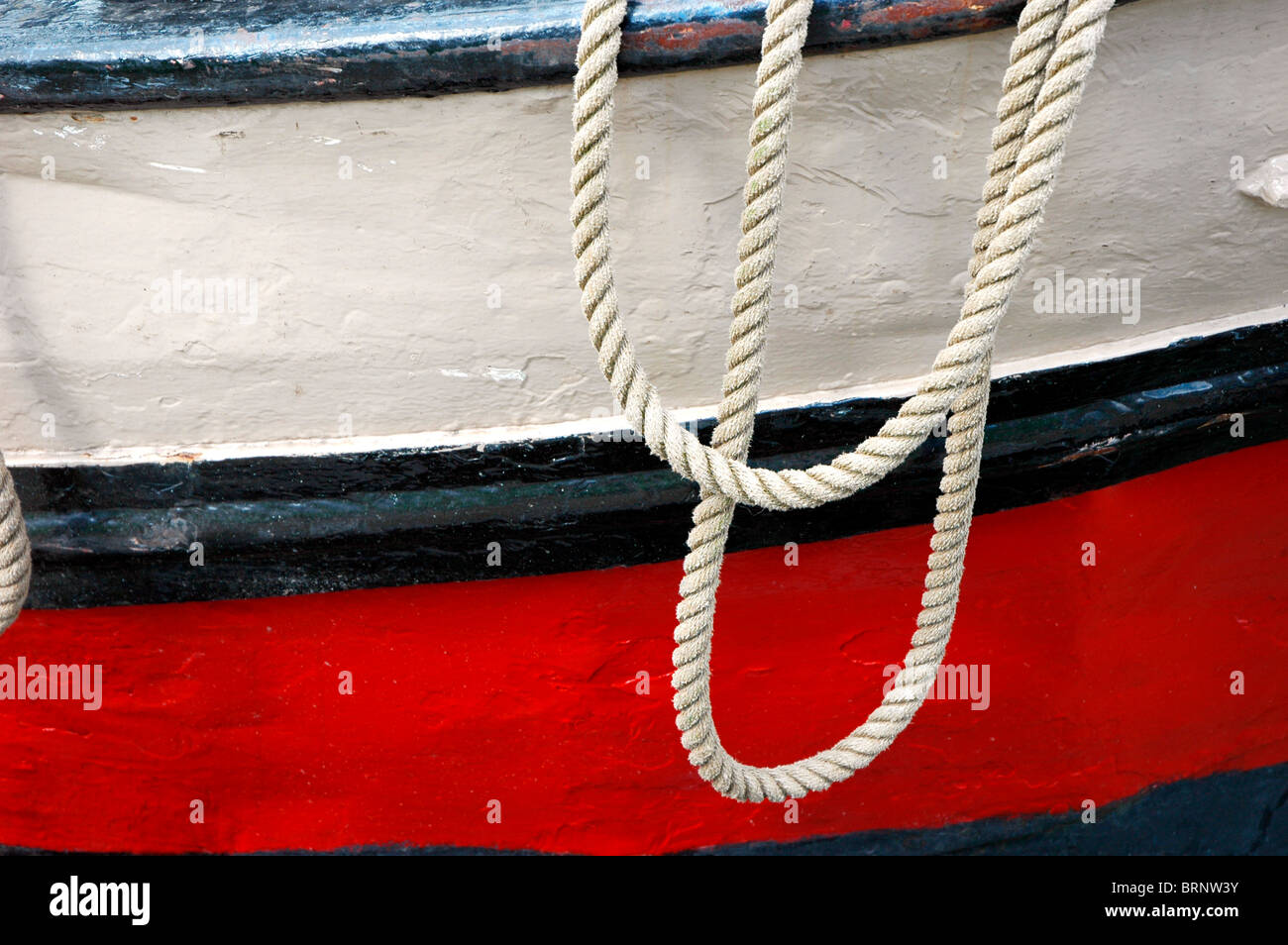 Close-up of the hull of a boat and a length of rope Stock Photo - Alamy