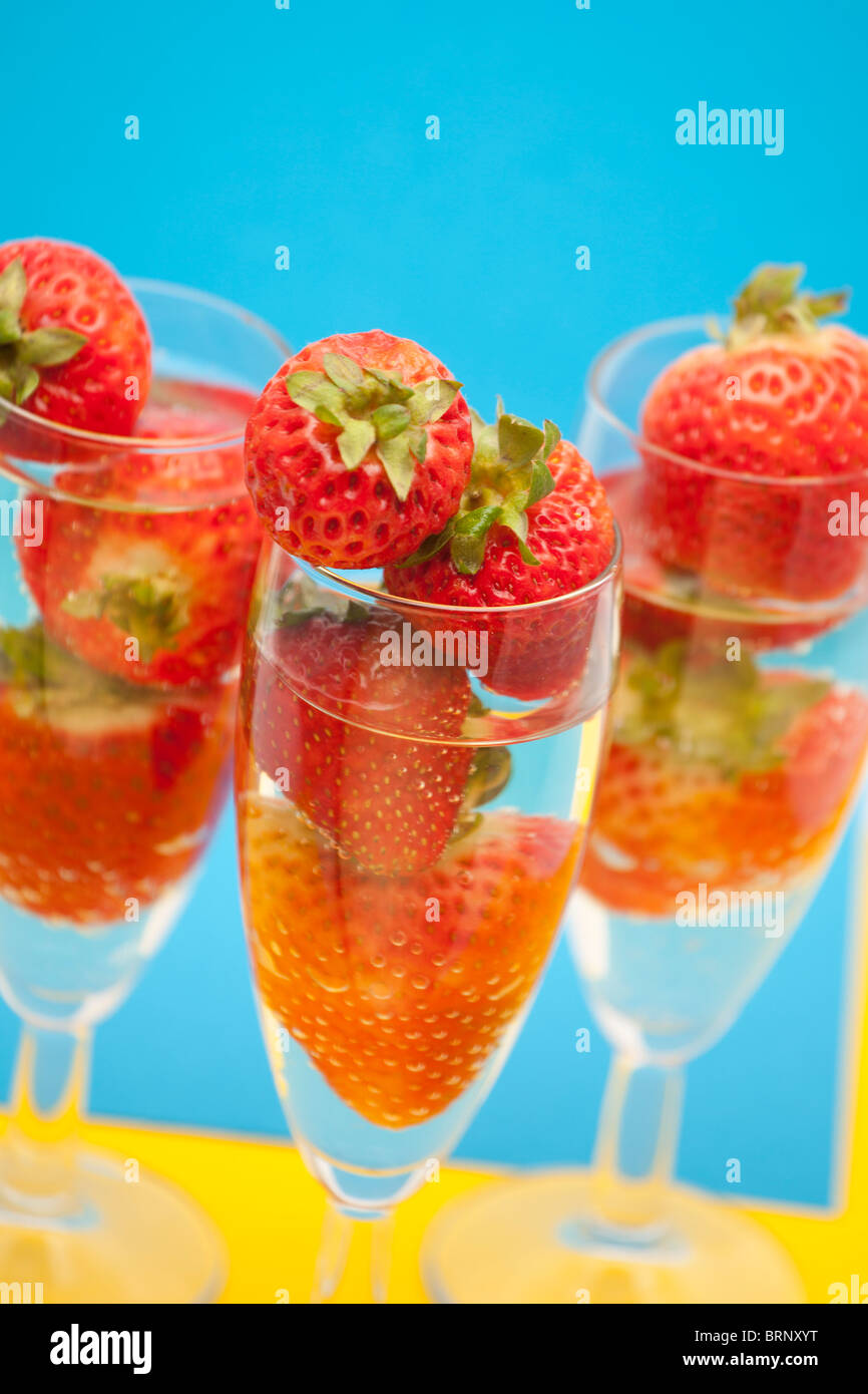 Champagne flutes containing champagne and strawberries, close-up Stock ...
