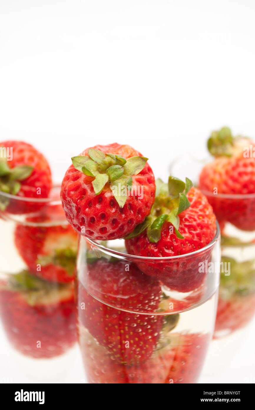 Champagne flutes containing champagne and strawberries, close-up Stock ...