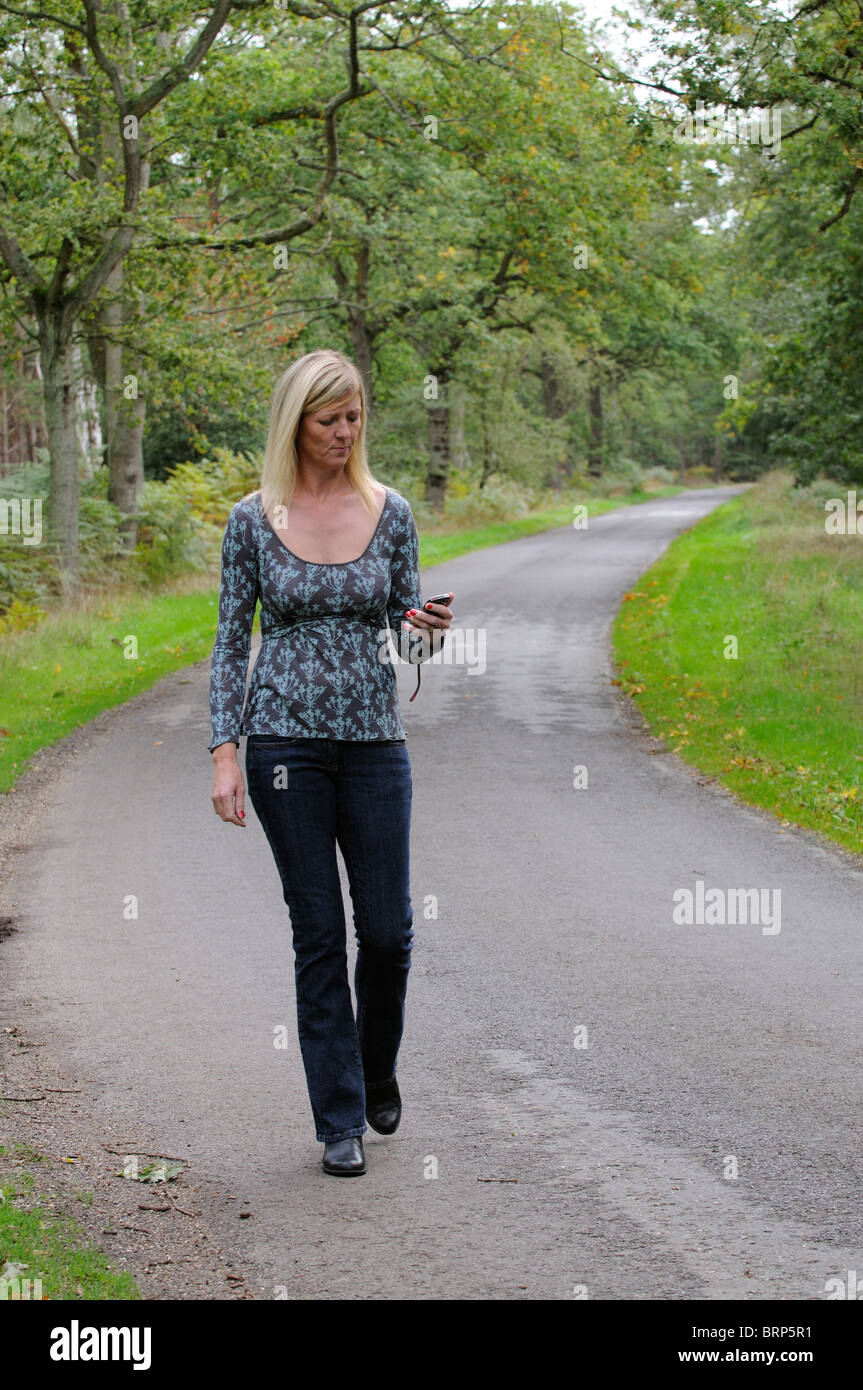 Woman walking down country lane hi-res stock photography and images - Alamy