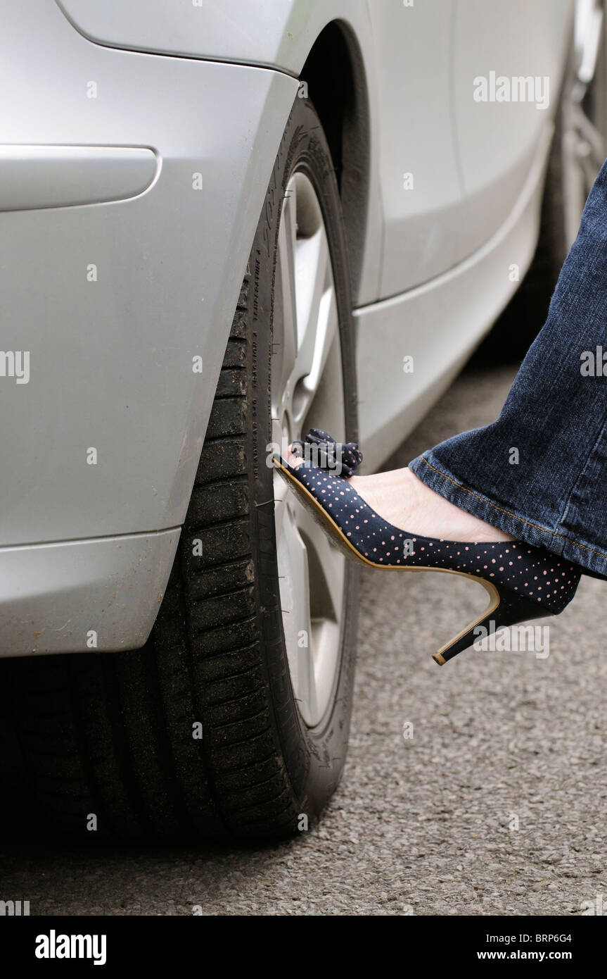 Female motorist kicking car wheel Stock Photo - Alamy